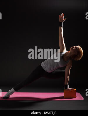 one woman exercising stretching triangle pose yoga in silhouette studio ...