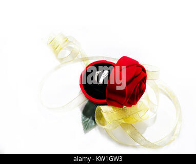 Silver ring in red gift box, bouquet of white flowers on wooden ...