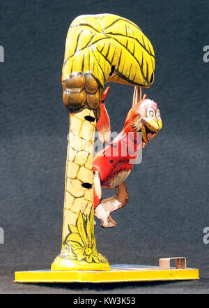 Bombo is a vintage tin toy monkey depicted in a tree. It represents a ...