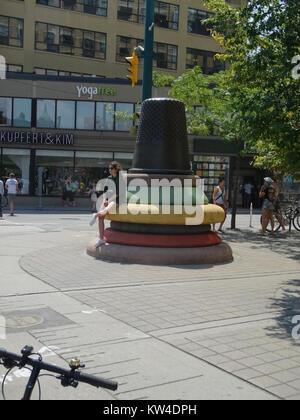 A large thimble sculpture stands in front of an architecturally ...