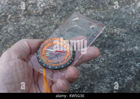 Hand holding a compass on an orienteering map Stock Photo - Alamy