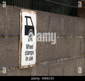 sign warning of wheel clamping for unauthorised parking Stock Photo - Alamy