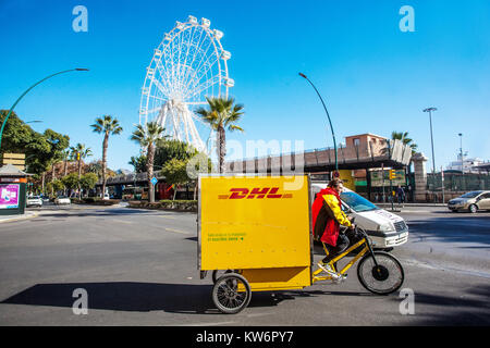 DHL parcel delivery man in uniform working at cycling along road on ...