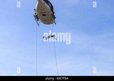 Soldier rappelling from helicopter in blue sky Stock Photo - Alamy