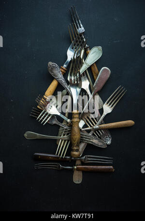 Christmas tree shaped with vintage silverware on dark wooden background ...