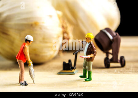 miniature figurines working hard together in order to make garlic best ...