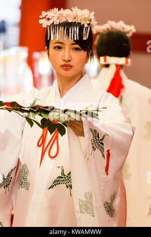 Japan, Kobe, Ikuta shrine. Portrait of a Miko, a shrine maiden, wearing ...