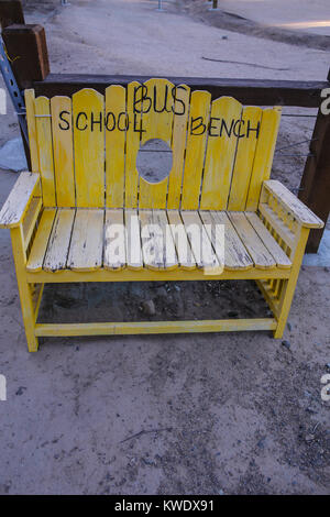 A yellow wooden school bus stop bench in a rural southern California ...