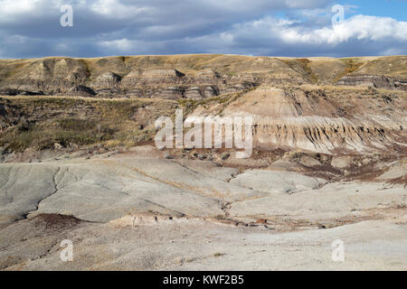 Eroded slopes in Alberta badlands, with sandstone layer above bentonite ...