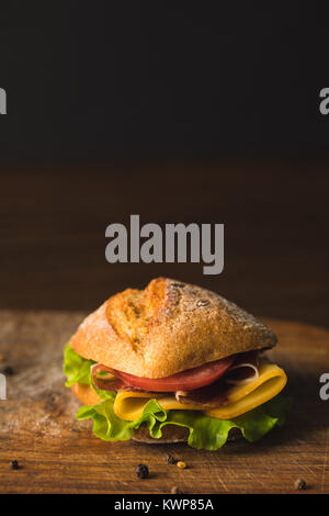Appetizing sandwich on a wooden board. Baguette sandwich with filling ...