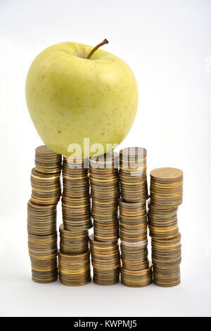 Yellow apple with coins isolated on white background Stock Photo - Alamy