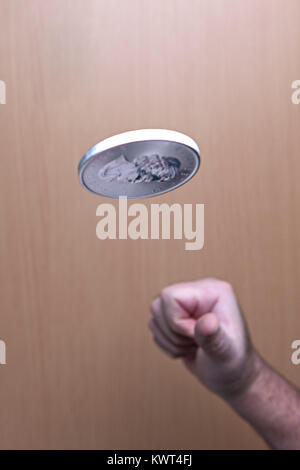 A conceptual image of flipping a Canadian silver coin up in the air ...