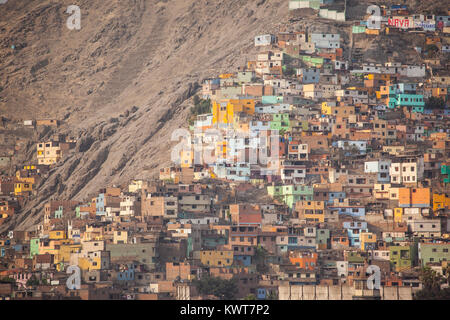 A colorful neighborhood on the outskirts of Lima, Peru. A large cross ...