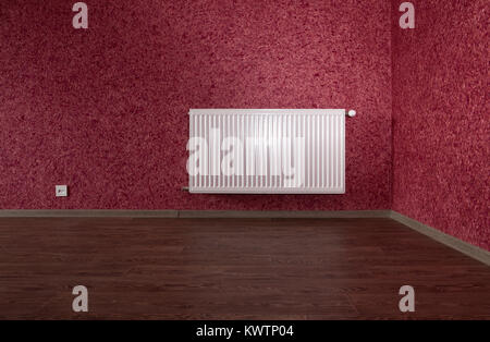 white heating radiator under in red room Stock Photo - Alamy