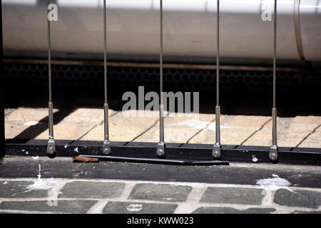 DIscarded Straw underneath a railing Stock Photo - Alamy