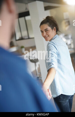 Woman pulling man's arm to follow her inside house Stock Photo - Alamy