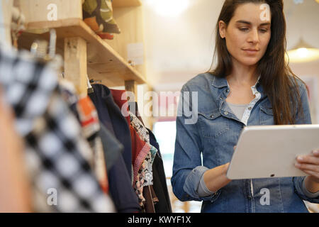 Shop owner checking stocks with digital tablet Stock Photo - Alamy