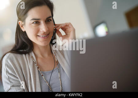 Home-office teleoperator talking on phone with headset Stock Photo - Alamy