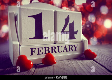 Calendar with date 14 FEBRUARY and gift on counter in kitchen, closeup ...