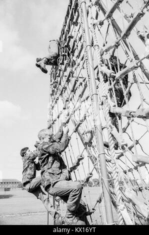 British army squaddies undergoing basic training climb over rope ...