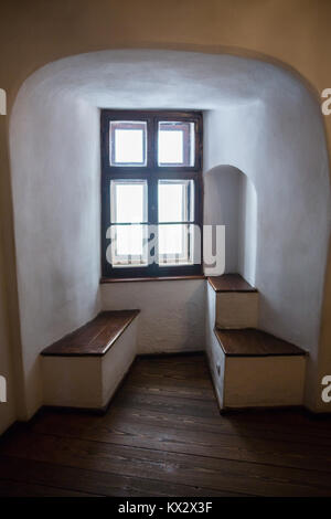 View from a dark stone window reveals a distant ancient fortress ...