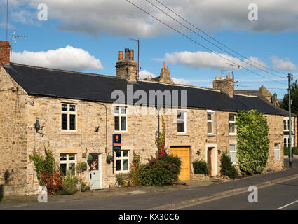 Traditional British stone-built cottages with pristine garden borders ...