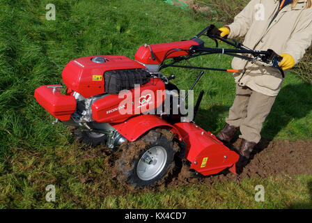 Rotavators in action in a country garden Stock Photo - Alamy