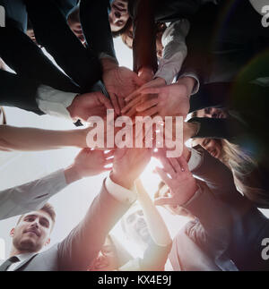 Large successfull business team showing unity with their hands together ...