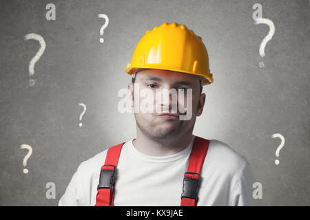 Confused young handyman with question marks Stock Photo - Alamy