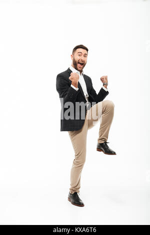 Full length portrait of a happy cheery man celebrating success while ...