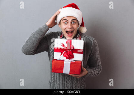 Confused man in sweater Santa Christmas hat pointing fingers himself ...