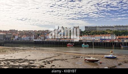 Whitby: Boats stranded at low tide in the fading light with the town in ...
