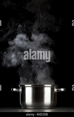 Steaming pot on black background Stock Photo - Alamy