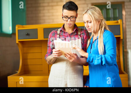 Two women collaborating at a modern work desk during a creative meeting ...