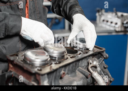 the mechanic installs a new piston. Disassemble engine block vehicle ...