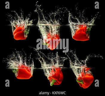 Red bell pepper falling in water on black Stock Photo - Alamy