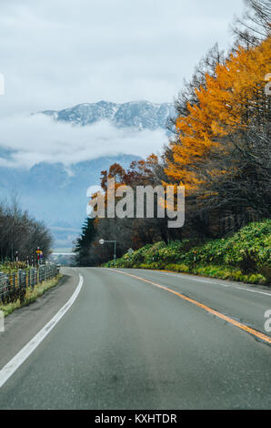 Scenic view of small farm located on green grassy meadow in valley near ...