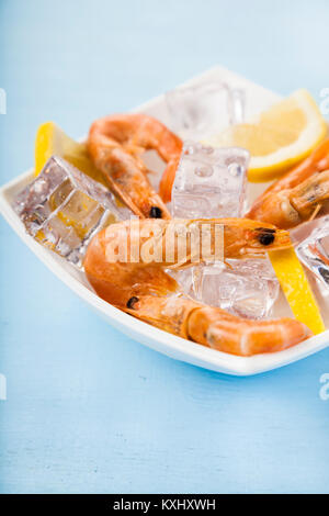 Fresh shrimp on ice on blue table, top view. Culinary seafood eating ...