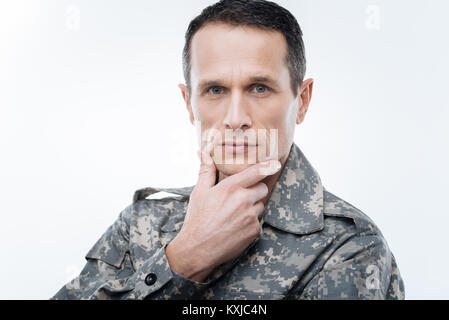 White military man holding his chin and looking at camera isolated over ...
