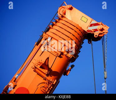 Mobile truck-mounted crane lifting heavy concrete building materials on ...