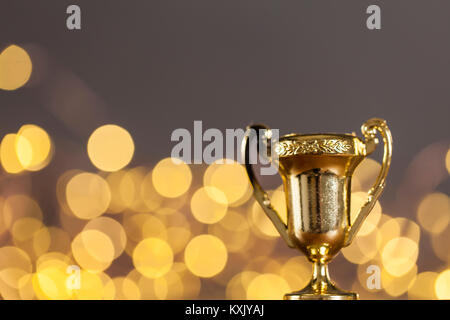 Gold award trophy against bright blurred lights Stock Photo - Alamy