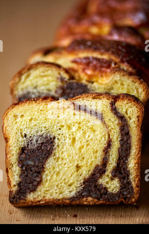 A closeup of a sliced fresh baked vanilla cake with white sugar icing ...