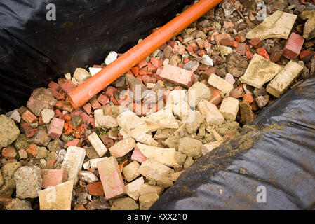 A newly dug pit filled with brick and stone rubble to form a rainwater ...
