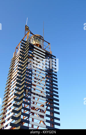 Historic white lighthouse and white wooden beach huts on the beach of ...