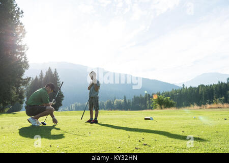 Father adjusting golf ball on tee Stock Photo - Alamy