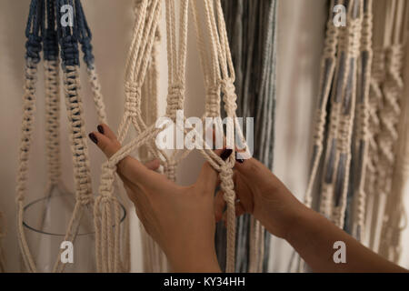 Woman knotting strings Stock Photo - Alamy