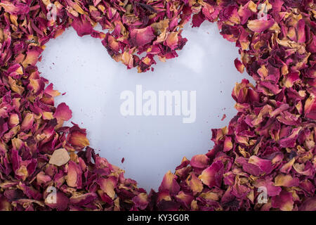 Dry petals form a heart shape on a white background Stock Photo - Alamy