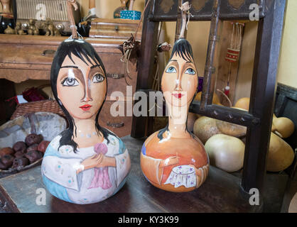 Painted faces on pumpkins and other art works in a small souvenir shop ...