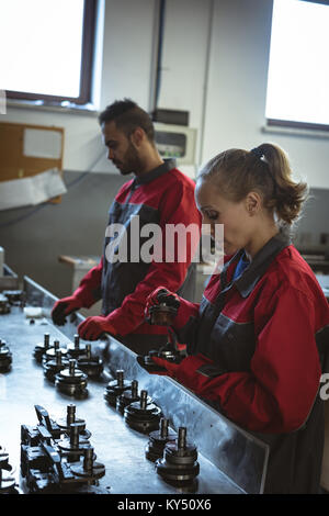 Two workers checking machine parts Stock Photo - Alamy
