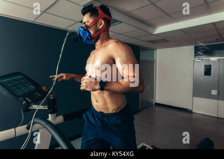 VO2 max test. Fit young man running fast on treadmill with a mask ...